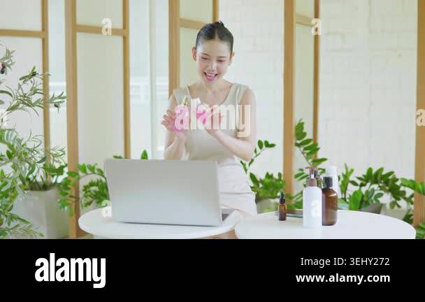 Woman holding bottles smiling at laptop Stock Video Footage - Alamy