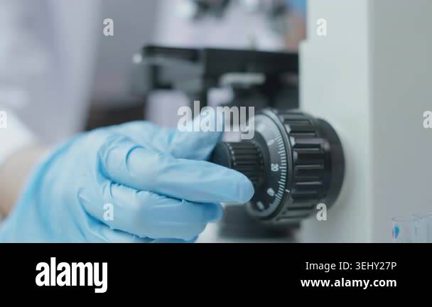 scientist adjusting microscope focus using gloved hand Stock Video ...