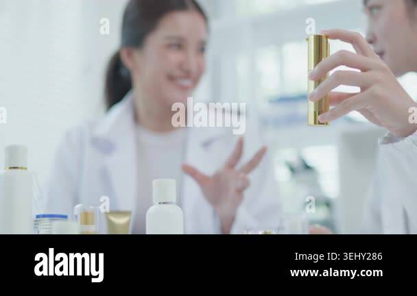 Smiling scientists presenting skincare products in laboratory Stock ...