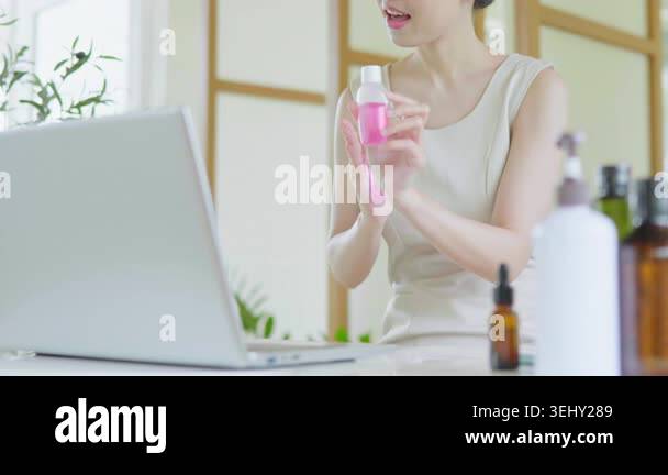 Woman holding pink bottle near laptop screen Stock Video Footage - Alamy