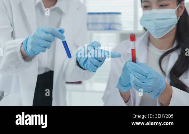 Scientists examining test tubes with colored liquids Stock Video ...