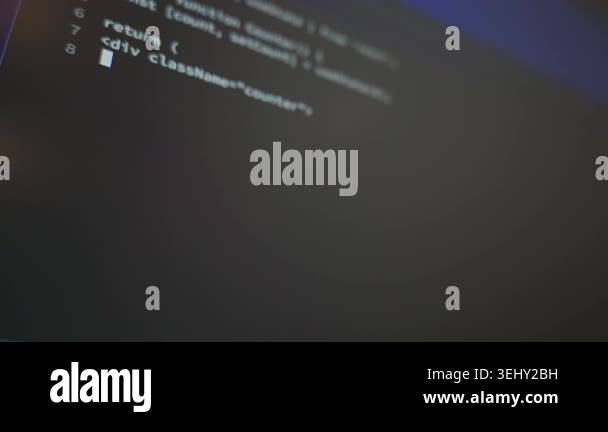 Macro shot of Javascript React code being typed out on a dark mode ...