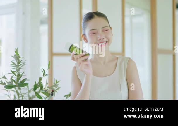 Woman smiling while holding green bottle indoors Stock Video Footage ...