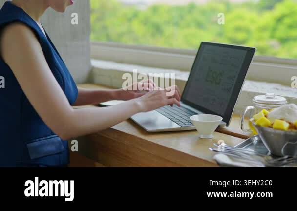 Businesswoman typing on laptop near window Stock Video Footage - Alamy