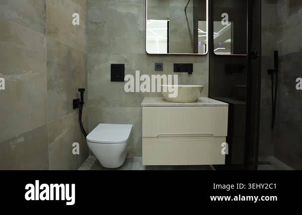 Compact bathroom featuring wallmounted toilet and vessel sink, matte ...