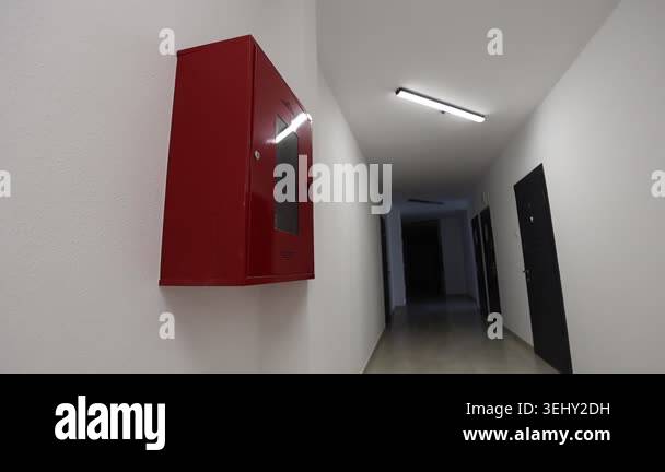 Red fire cabinet mounted in corridor on white wall, recessed ceiling ...