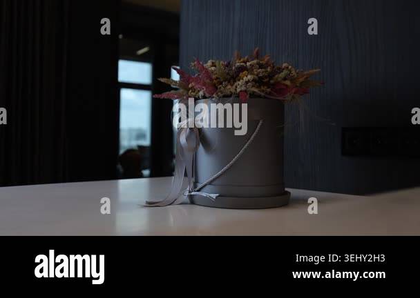Flower arrangement on modern kitchen counter, ribbon tied box vase ...