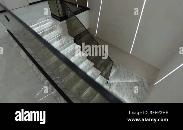 Modern marble staircase with glass railing angled overhead shot ...