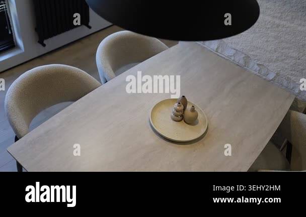 Wooden Dining Table With Decorative Plate And Pendant Lamp Overhead ...