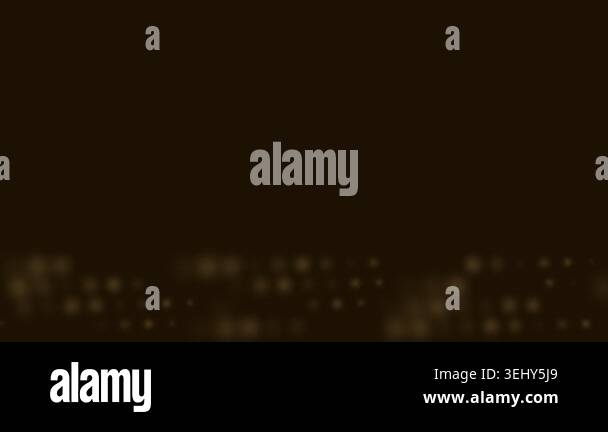 Abstract golden light particles glowing softly on a dark black ...