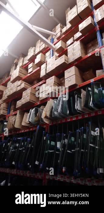 High shelves stacked with boxes and car glass in warehouse. No people ...