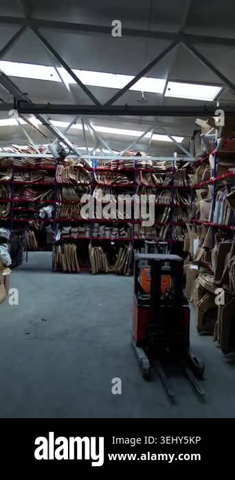 Warehouse filled with stacked cardboard boxes on tall shelves ...