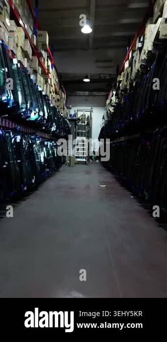 Long warehouse aisle lined with stored car parts. Shelves reach high ...