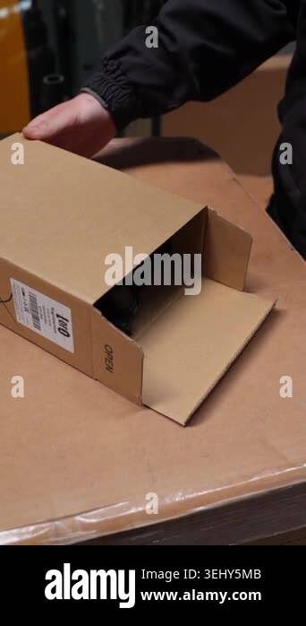 Person opens cardboard box revealing black radiator. Hands carefully ...