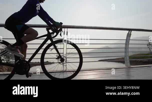 Person Riding bike on seaside road Stock Video Footage - Alamy