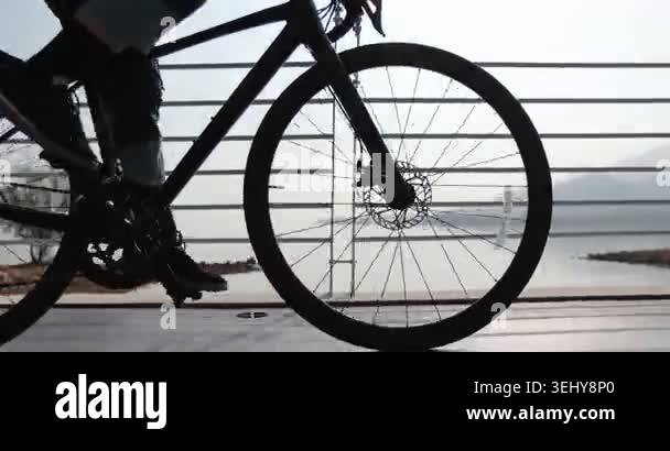 Person Riding bike on seaside road Stock Video Footage - Alamy