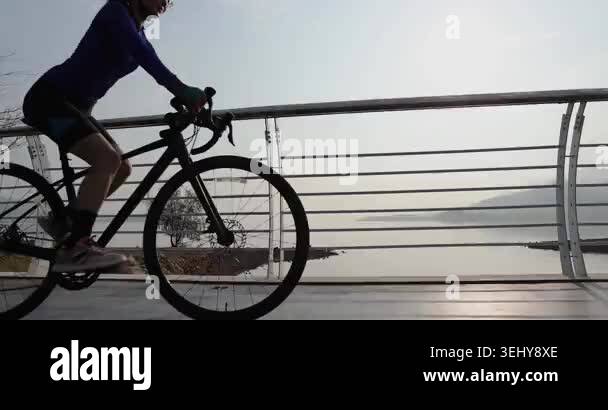 Person Riding bike on seaside road Stock Video Footage - Alamy