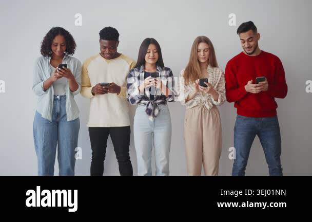 Five people of varying ethnicities stand in a line, each focused on ...