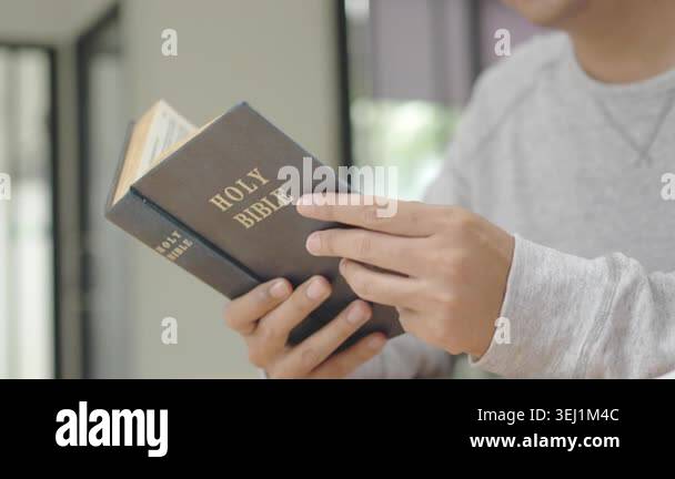 Person praying with a Holy Bible, expressing faith and spiritual ...