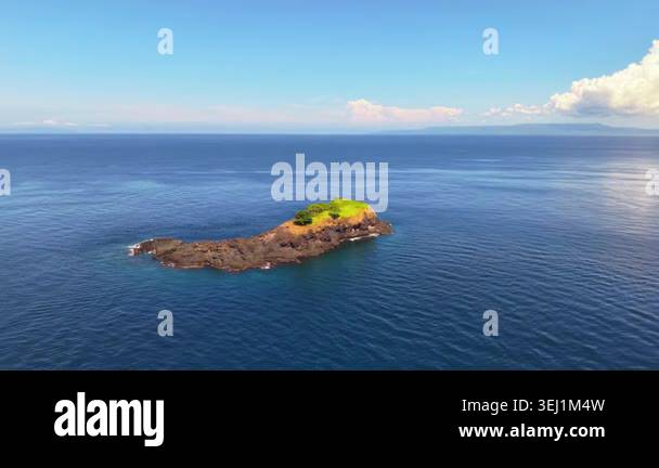 Aerial view of a small isolated tropical islet with green grass and ...