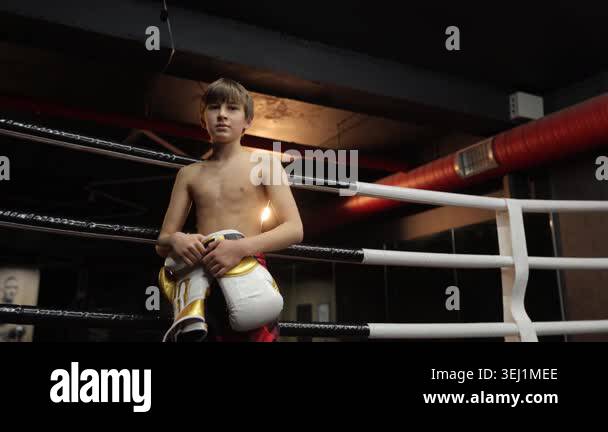 Focused young athlete carefully wrapping his hands with tape inside a ...