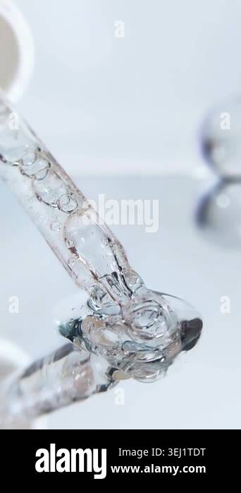 Closeup serum pipette clear bubbly liquid on glass reflection beauty ...