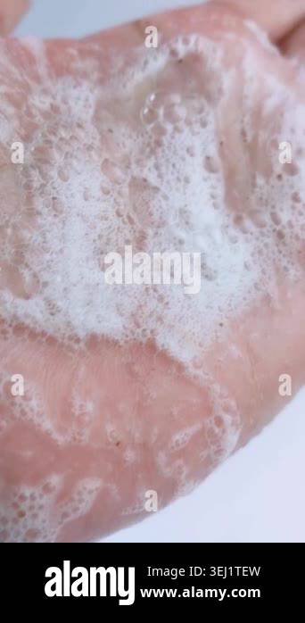 Close up of palm covered in soap bubble foam. Hand hygiene, cleansing ...