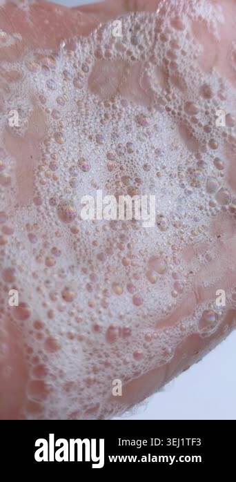 Gently rubbing palm of hand filled with rich soap foam. Close up view ...