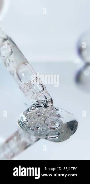 Close up serum pipette with bubbly liquid. Beauty liquid on glass ...
