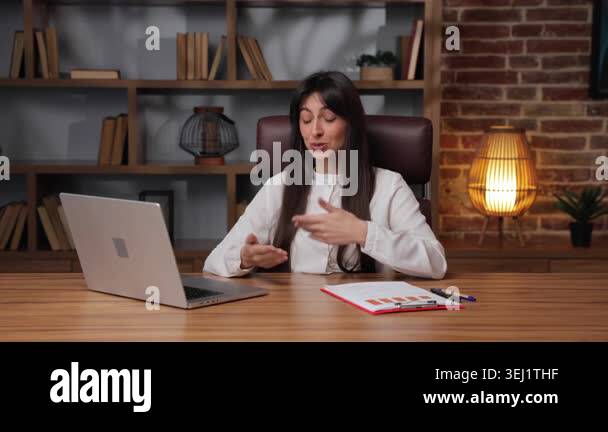 Caucasian business woman talks with colleagues through video chat while ...