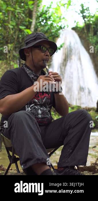A male musician plays a wind instrument called a tin whistle against ...