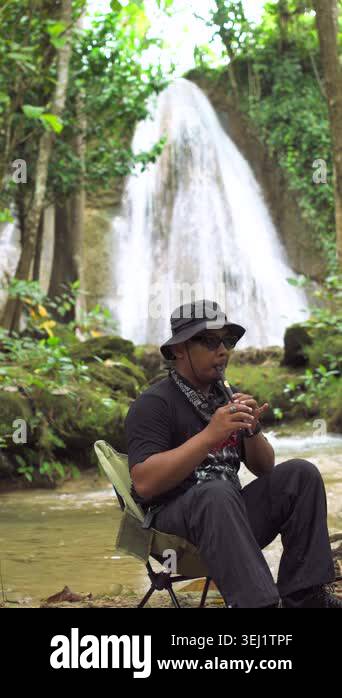 A male musician plays a wind instrument called a tin whistle against ...