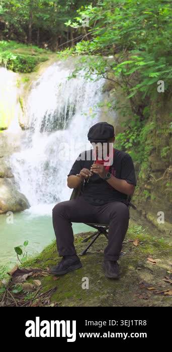 A male musician plays a wind instrument called a tin whistle against ...