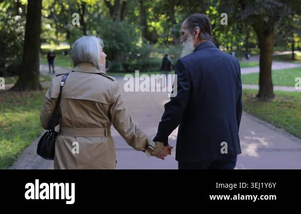Happy senior couple walking and holding hands, enjoying a romantic ...