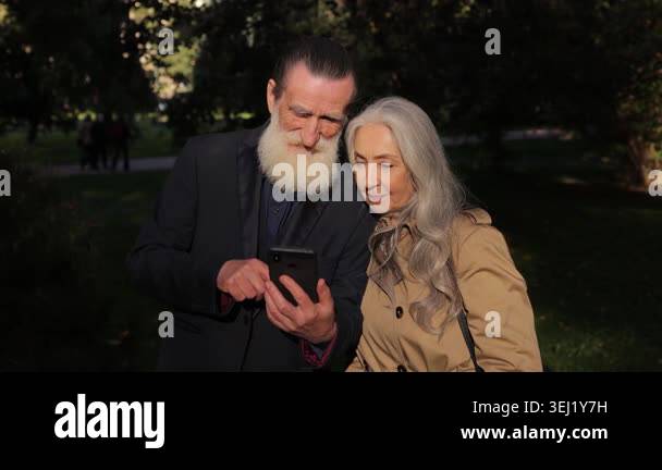 Happy elderly couple with gray hair enjoying time together using a ...