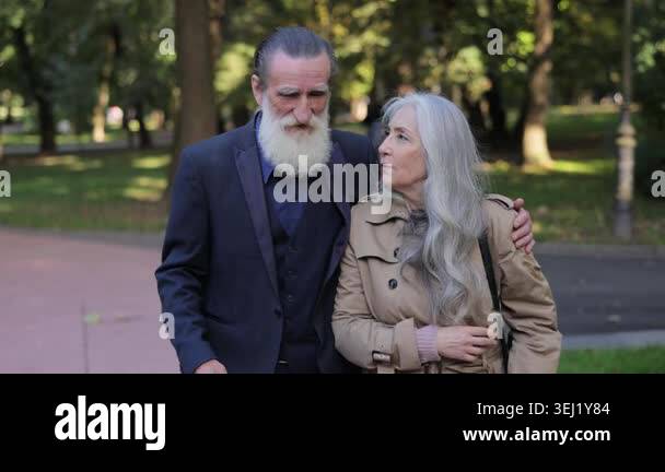 Happy elderly couple with gray hair enjoying a walk together and ...
