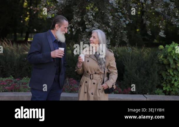 Elegant senior man and woman enjoying a conversation and drinking ...