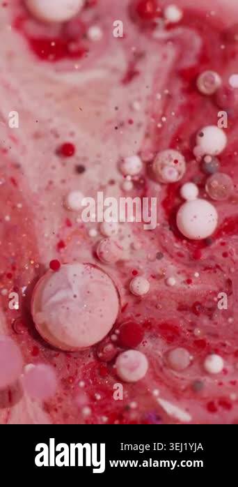 Vertical video. Oil fluid. Paint art. Defocused red white pink color ...