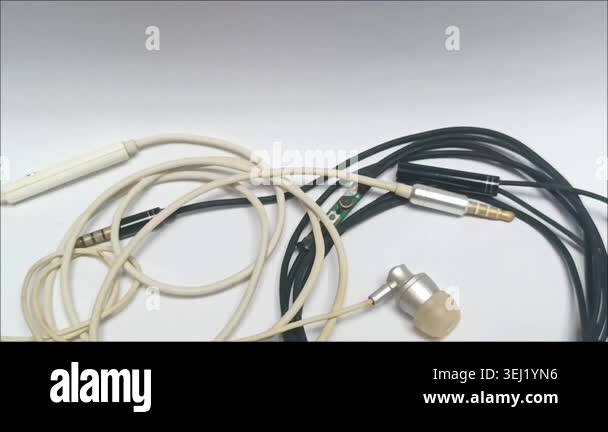 Close up details of black and white wired earphones with gold plated ...