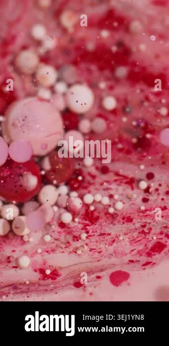 Vertical video. Oil bubbles. Paint fluid. Defocused red pink white ...