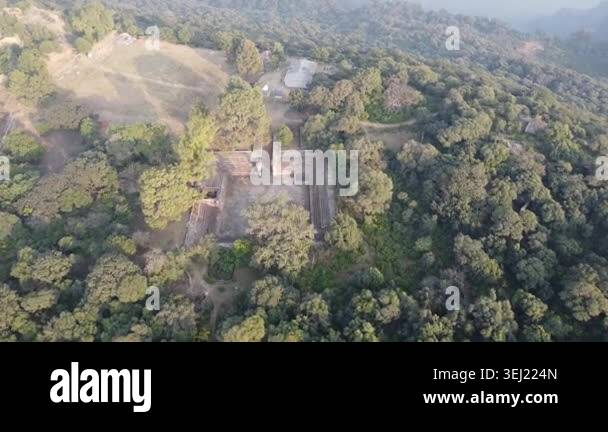 Tilla jogian ancient stone water tank surrounded by trees on hilltop ...