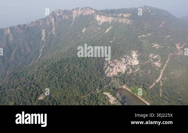 Tilla jogian ancient pond surrounded by mountains and jungle then drone ...