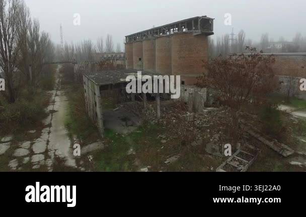 Drone view of abandoned industrial silos, ruined factory buildings and ...