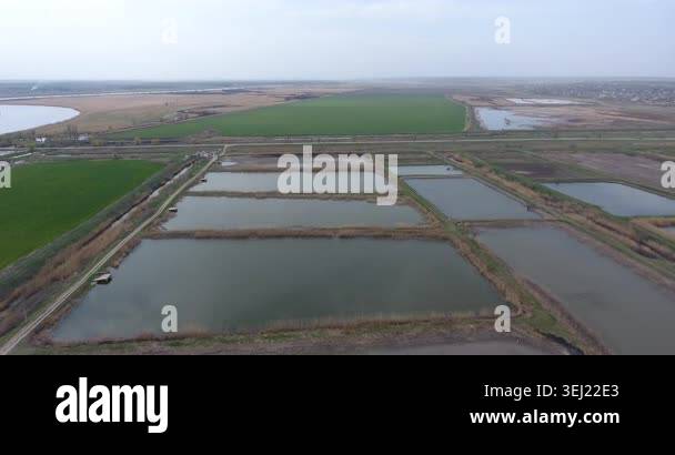 Aerial footage of fish ponds, farmland, and irrigation channels in open ...