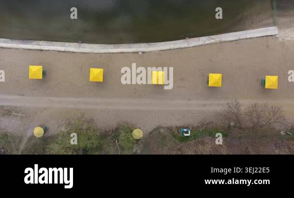 Aerial top-down view of an empty sandy river beach with a row of bright ...