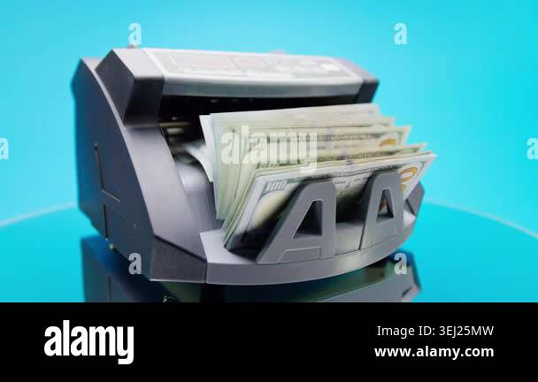 Close-up of a cash counting machine processing US dollar bills ...