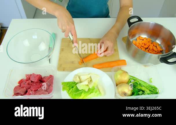 Woman cuts vegetables for traditional goulash, cozy kitchen mood ...