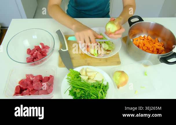Woman cuts vegetables for traditional goulash, cozy kitchen mood ...