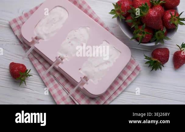 Pink silicone mold filled with creamy strawberry ice cream and fresh ...