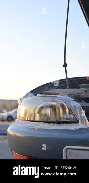 Close-up of a car headlight covered with tape around the perimeter ...